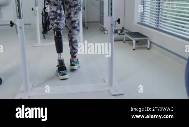 Rear view of a Caucasian male physiotherapist helping a Caucasian ...