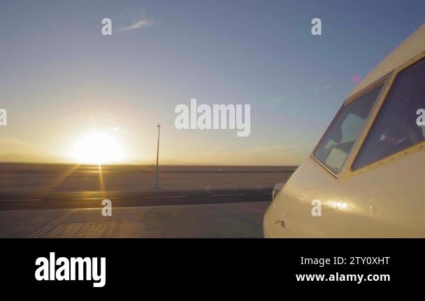 Jet plane in airport runway as silhouette in front of large sunset 4K ...