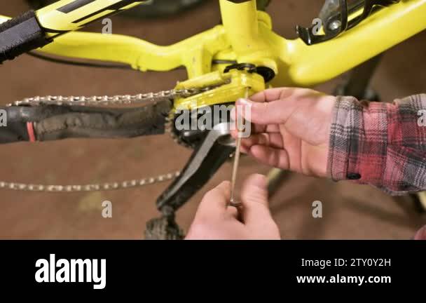 Close-up maintenance of a mountain bike. Male hands adjust the chain ...