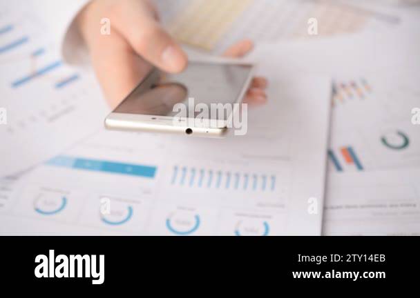 Man Using Mobile Phone on table background with Graph Money Stock ...