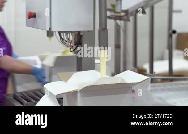 The process of packing the oil or spread into the box. The machine puts ...