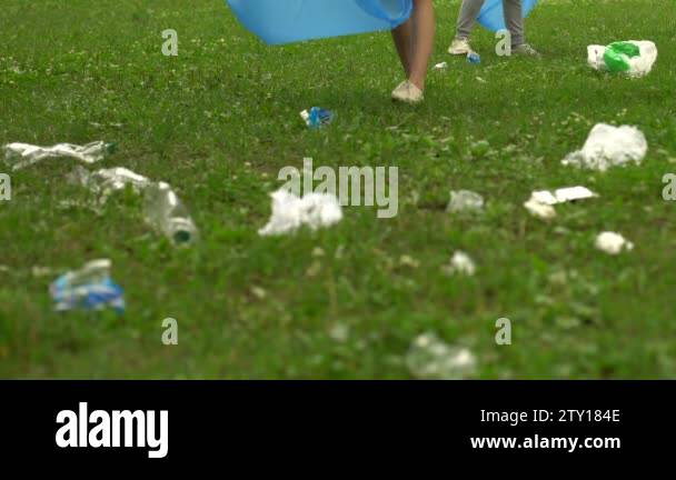 People picking up rubbish in plastic bags, waste treatment problem ...