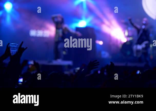 Crowd of people waving their hands in rythm of song on a rock concert ...