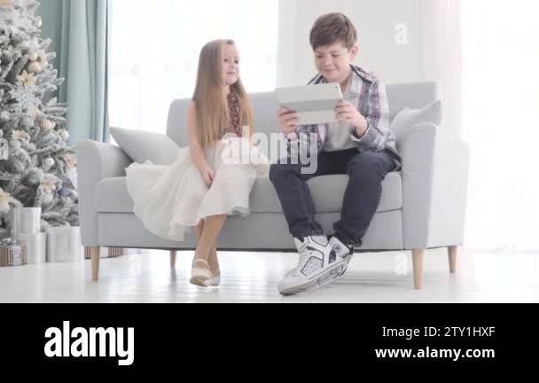 Pretty Caucasian girl touching boys shoulder and waving. Boy making ...