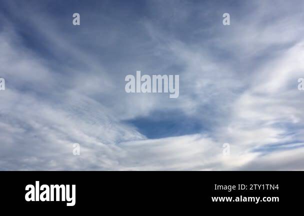 white clouds disappear in the hot sun on blue sky. Time-lapse motion ...