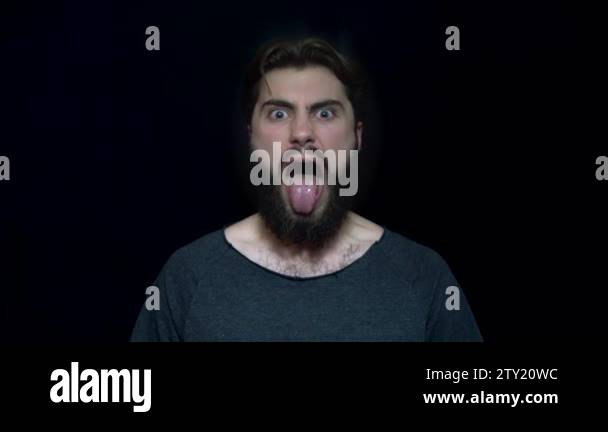 Young man with beard and tongue sticking out in rage. Angry young man ...