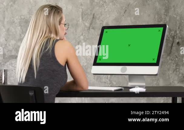 Woman freelancer looking at computer monitor. Green Screen Mock-up ...