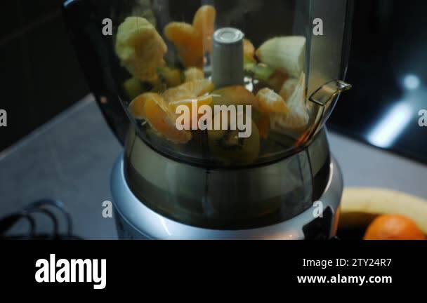 Cutted fruits in blender on kitchen. Preparing fruits smoothie, close ...