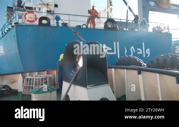 Towing a ship. Sailor of the Egyptian ship transfer the end of the rope ...