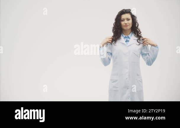 A serious young woman in a Caucasian woman in a laboratory robe looking ...