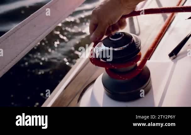 close up view of man using the capstan head to fixing the rope sailor ...