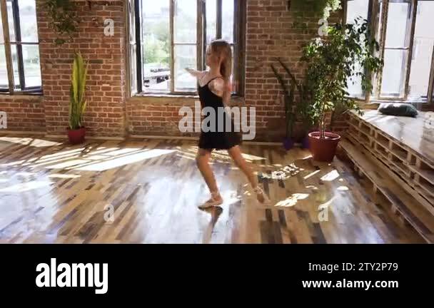Charming slim girl in black body and skirt performs a jump from ...