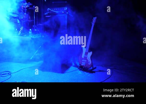 Rock concert background. Electro guitar left on the stage. Smoke at the ...