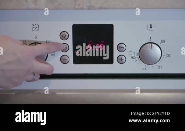 Female hand includes Metallic Toggle Switch of the Cooker Oven. Close ...