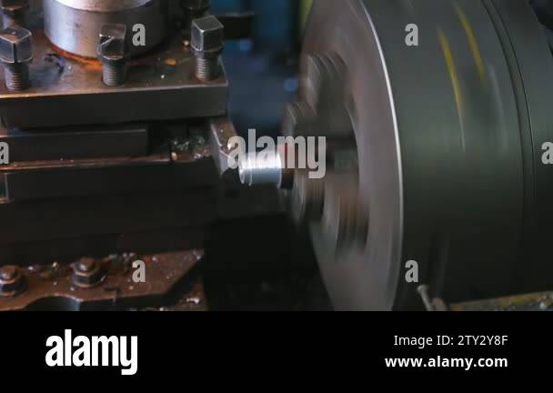 Whirling cylinder on a lathe machine peeling metallic chips in a big ...