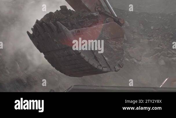 Slow motion loading of an excavator into mining truck. Close-up ...