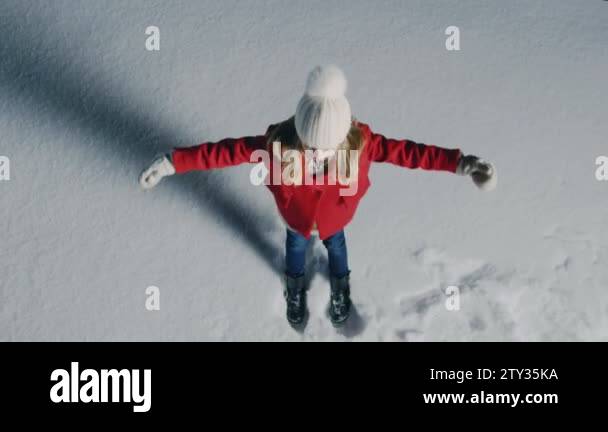 Top Down Footage of the Happy Cute Little Girl Falling into Snow, Lying ...