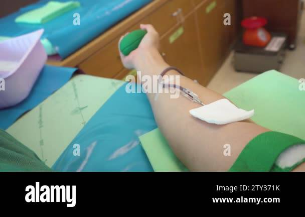 Blood donation. Male hand of blood donor and squeezing rubber ball for ...