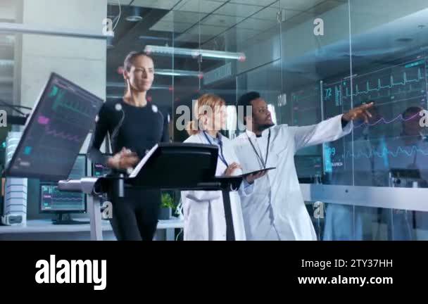 Woman Athlete Runs on a Treadmill with Electrodes Attached to Her Body ...