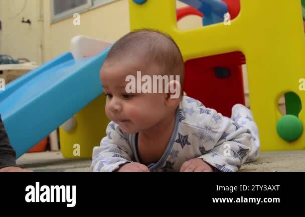cute tree months old baby boy is having tummy time outside while his ...