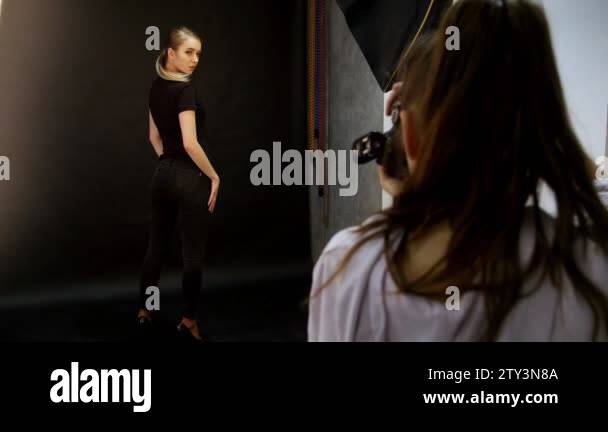 Young woman model having a photo session in the studio. Taking snaps of ...