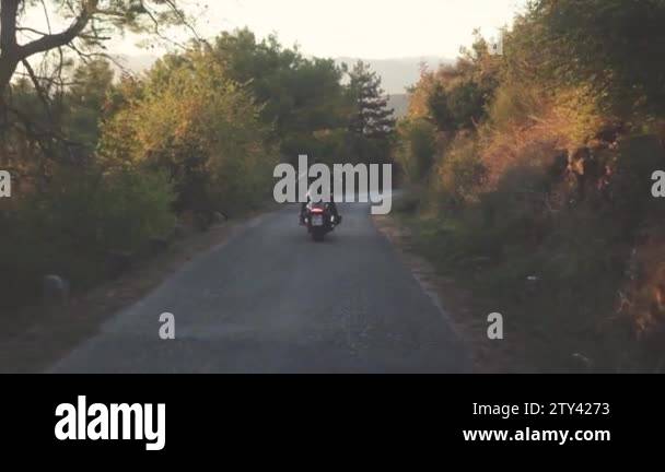 View from back of man riding motorcycle on forest road. Stock. Rear ...