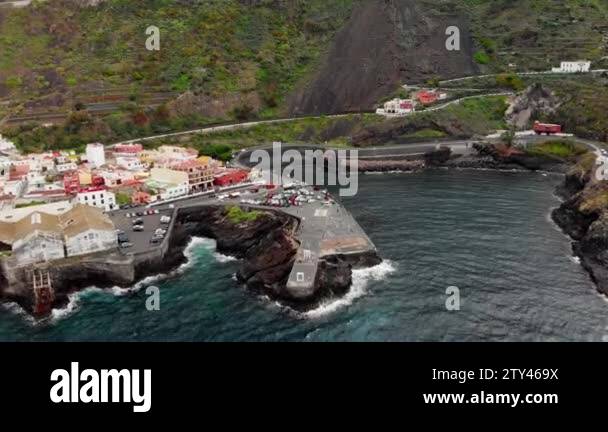 Aerial shot. Small town at the base of the mountains and volcano ...