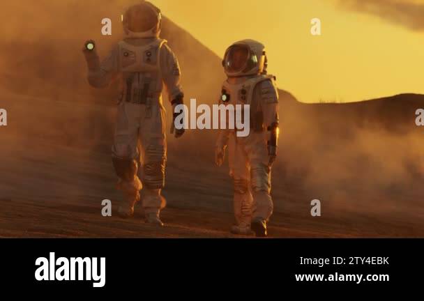 Two Astronauts Wearing Space Suits Walk Exploring Mars/ Red Planet. Space Travel and Solar ...