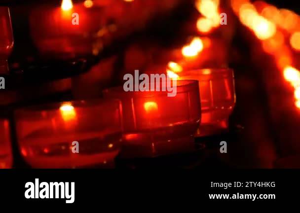 Burning memorial candles in Catholic church. Row of christian prayer ...