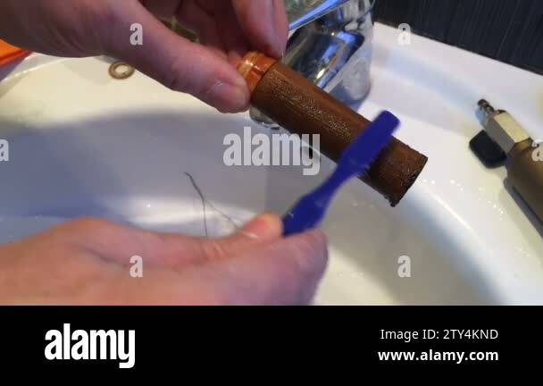 Plumber is cleaning the internal filter of pipe. Filter is clogged with ...