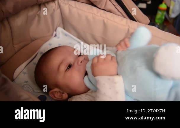 cute 3 months old baby boy making funny faces in baby carry cot Stock ...