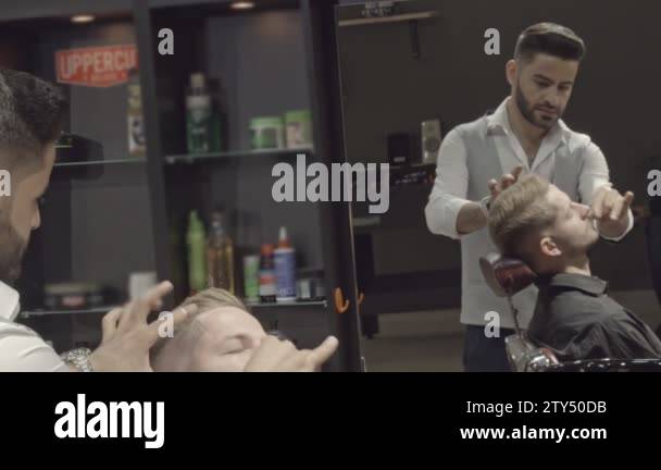 Professional barber in white shirt doing threading procedure and ...
