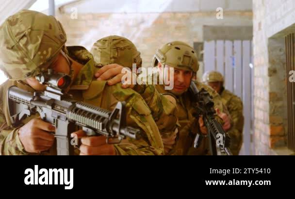 Front view of caucasian military soldiers standing and aiming with ...