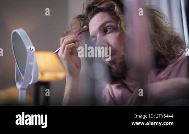 Shooting behind cosmetics, Caucasian male binary gender person applying ...