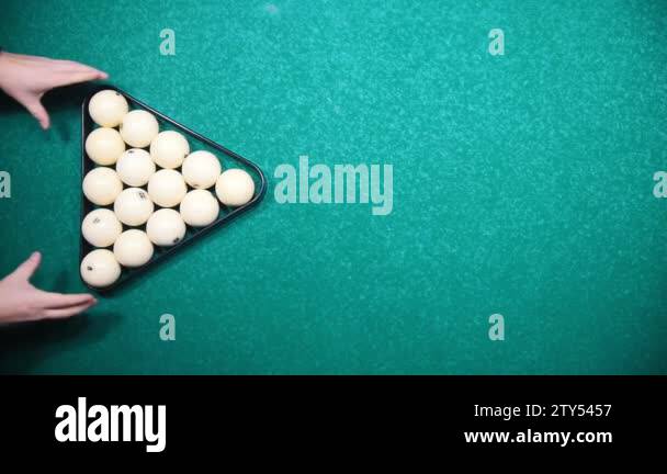 Forming a triangle of white billiards balls and breaking down the form ...