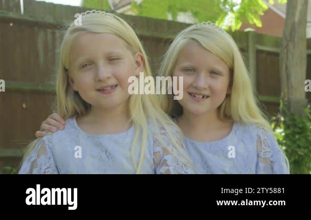 Portrait of pre teen twin caucasian girls looking at the camera themes ...