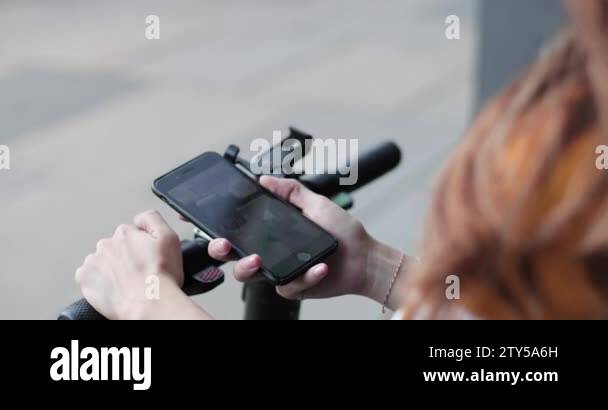 Female commuter scanning QR code on electric scooter Stock Video ...
