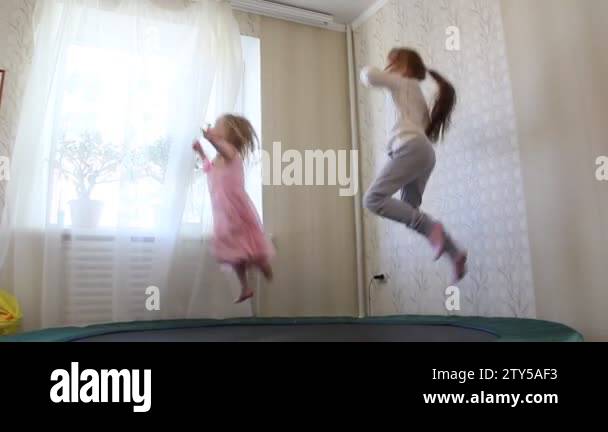 Two little girls jumping on trampoline Stock Video Footage - Alamy