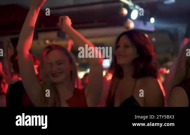 party in a nightclub. a crowd of dancing people. girls are having fun ...