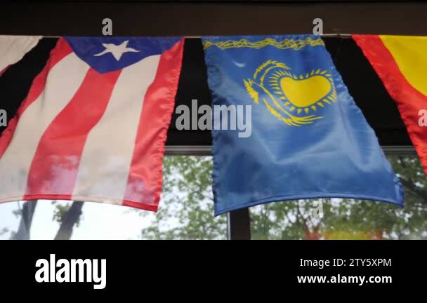 Close up of group of flags. Flags of different countries hang on wall ...
