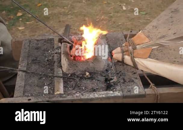 Blacksmiths working old fashioned bellows at the forge. The blacksmith ...