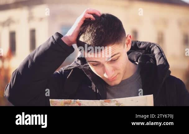 Handsome guy is learning the map. Lost in foreign city. Confused facial ...