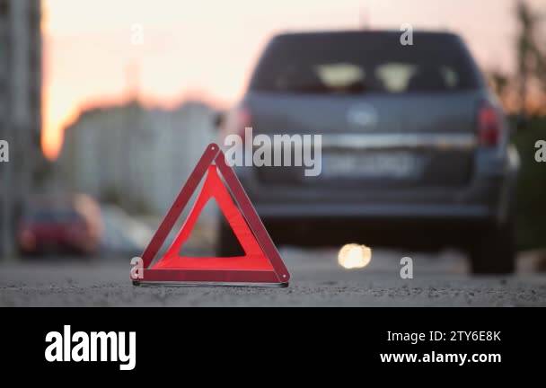 Red emergency stop sign behind broken blurred car with blinking lights ...