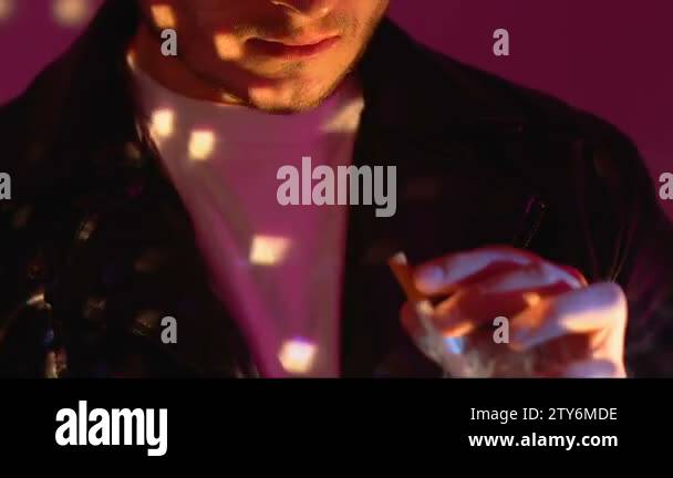 Drunk young man smoking cigarette dancing at night club party, wasting ...