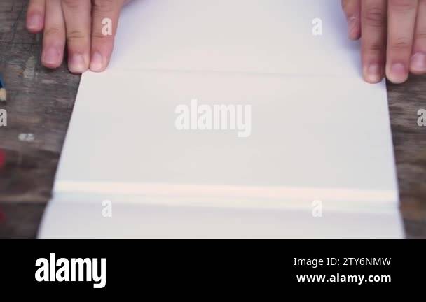 The woman puts the sheet of paper in half and tears off it from a basis ...