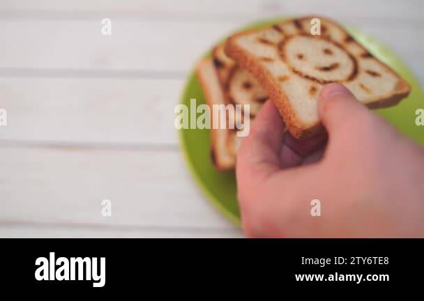 Detail of male hands spreading butter over a toasted bread slice ...