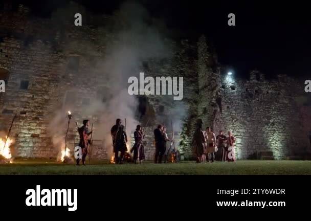 Archers launch fire arrows in the medieval castle at night during the ...