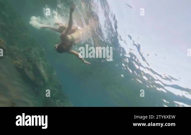 Young woman diving in crystal clear ocean water. Woman snorkeling in ...