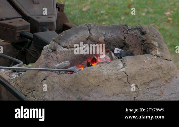 Medieval furnace with burning coals and fire lit with bellows in ...