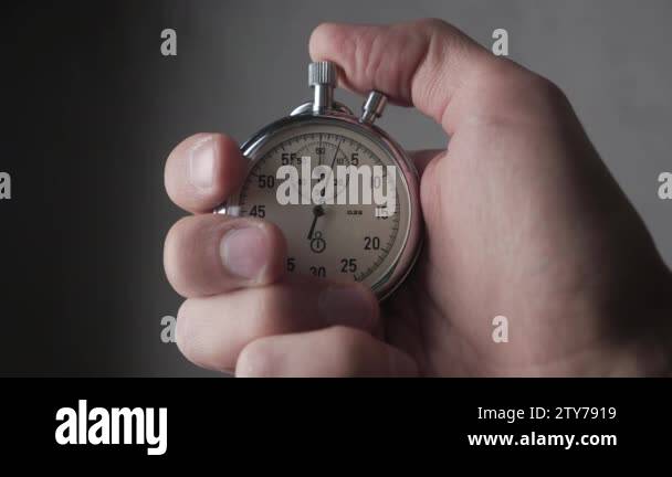 Close-up of one person starting up a stopwatch at grey background. 4K ...